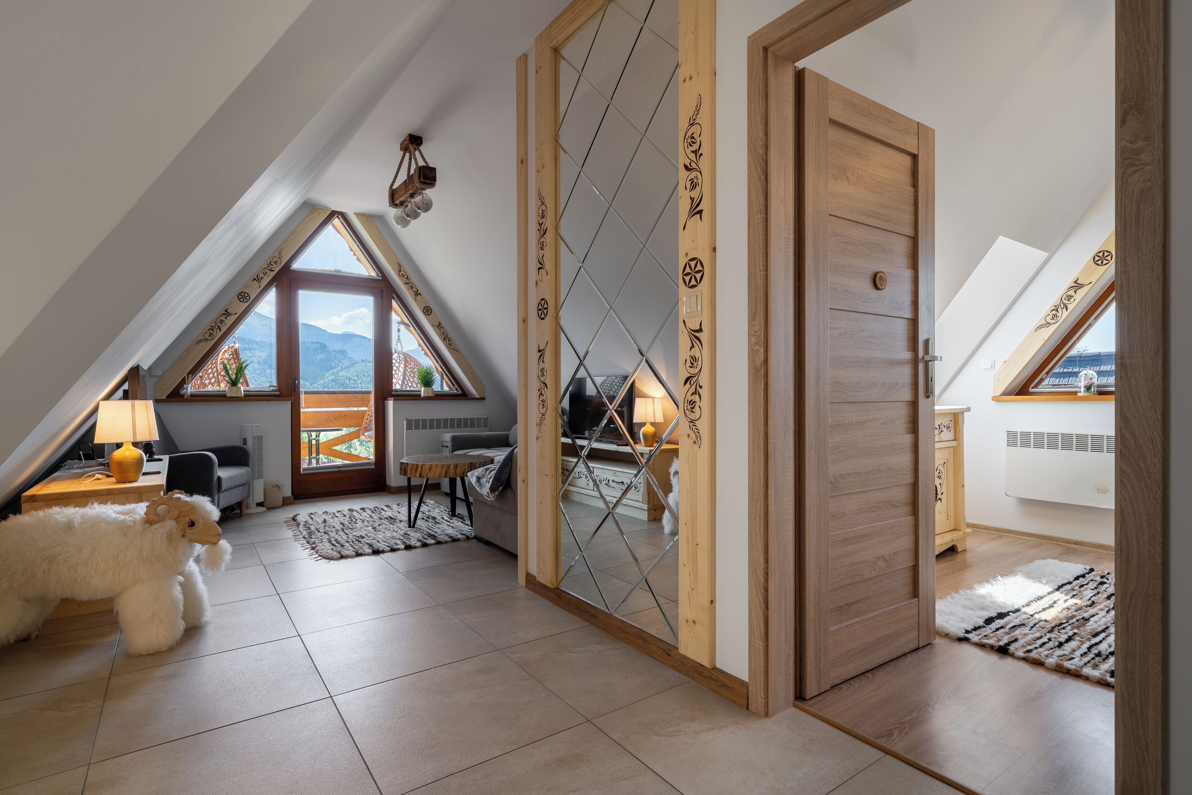 Quarto moderno no estilo loft com teto inclinado, janelas amplas e porta de madeira.
