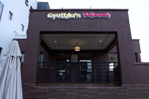 Entrada de restaurante com placa indicando 'Cynthia's Restaurant'.