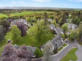 Uma área residencial com casas, gramados verdes e árvores.