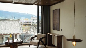 Interior moderno com vista para edifícios tradicionais e montanhas.