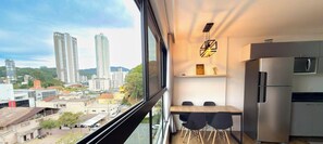Cozinha moderna com vista para a paisagem urbana, incluindo edifícios altos e uma rua.