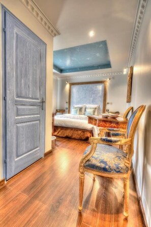 Quarto com uma cama grande, uma cadeira, cômoda e guarda-roupa.