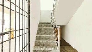Uma escadaria com guarda-corpos de metal e degraus de pedra.