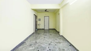 Um corredor com um ventilador de teto, uma porta e uma pia.