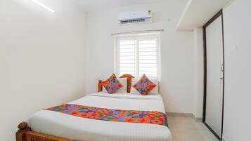 Quarto com cama, janela, ar condicionado e porta.