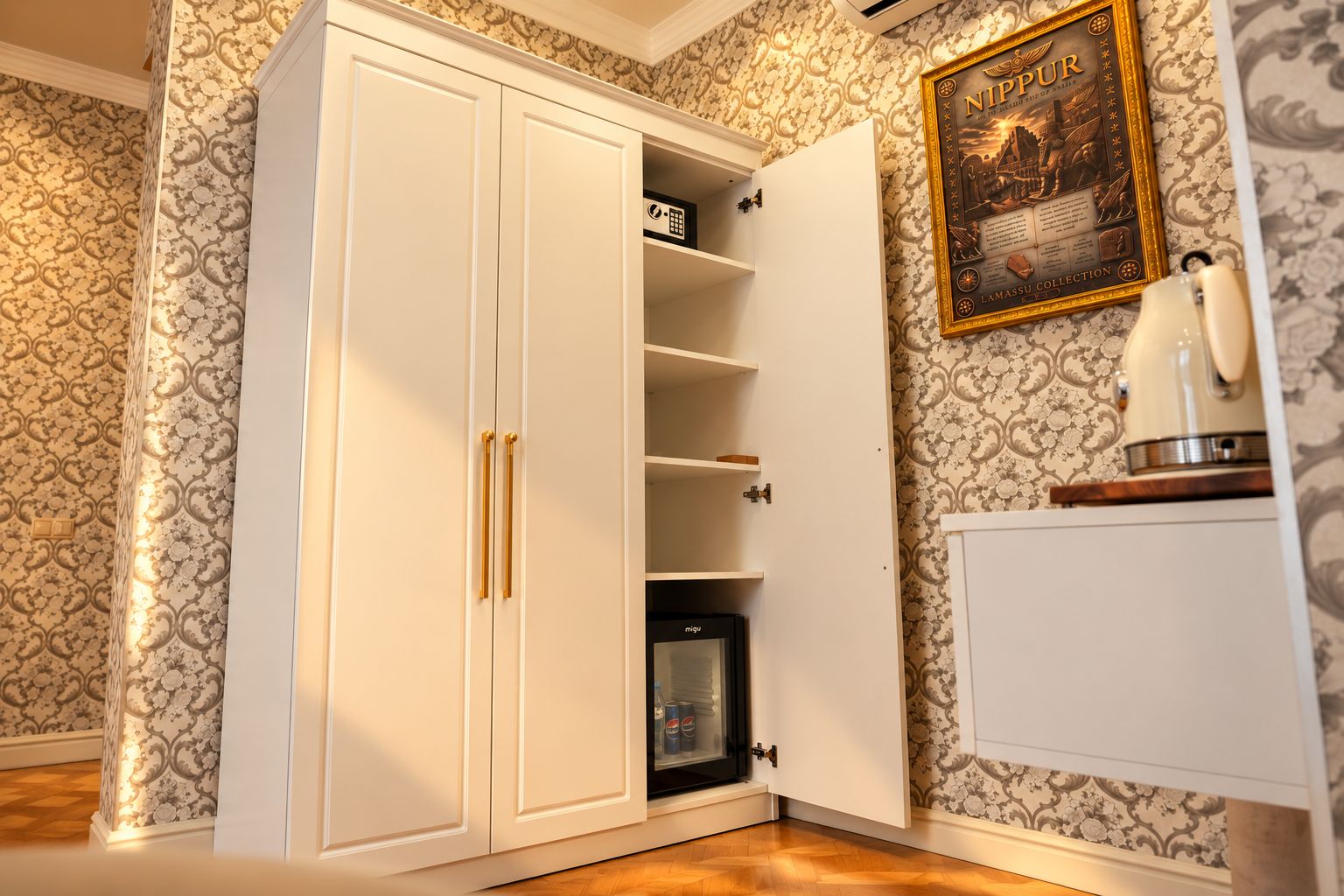 Quarto com guarda-roupa branco, quadro na parede e um pequeno armário com abajur.