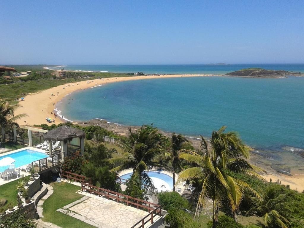 Um resort à beira-mar com piscina, praia e vista para o oceano.