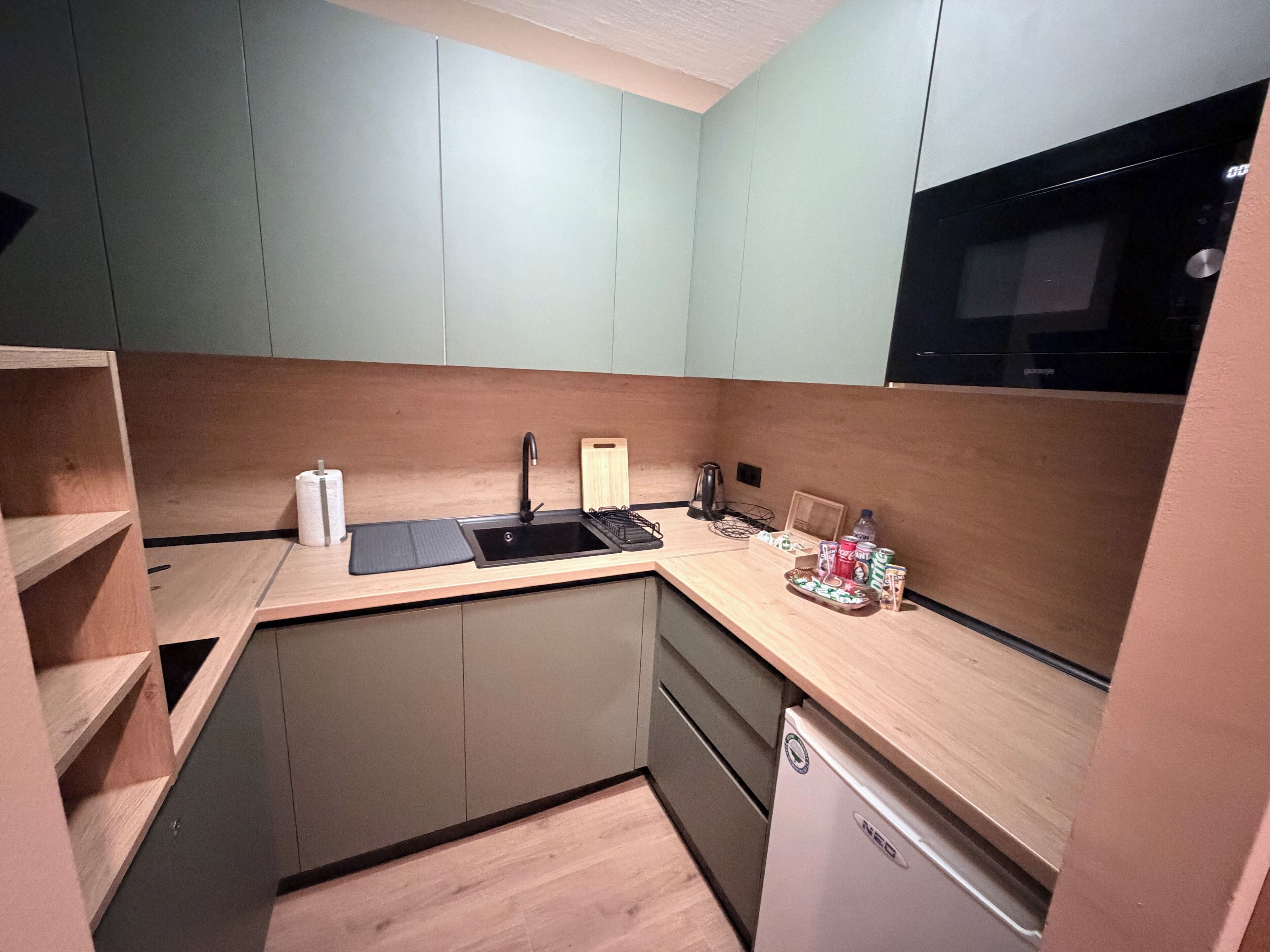 Uma cozinha compacta com pia, bancada e forno embutido.