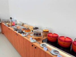 Disposição de buffet com diversos alimentos e recipientes.