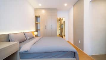 Quarto moderno com cama, mesas de cabeceira e guarda-roupa.