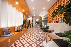Um interior moderno com piso estampado, áreas de estar e um balcão de recepção.