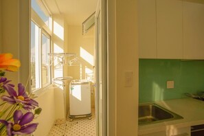 A kitchen with a sink, a refrigerator, and a window with a view.