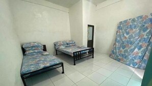 Quarto com duas camas, um espelho e uma cortina.