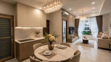 Uma cozinha moderna com bancada de mármore, mesa de jantar com cadeiras e um candelabro.
