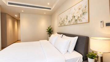 Quarto de hotel com cama, mesa de cabeceira, luminária e ar condicionado fixado na parede.