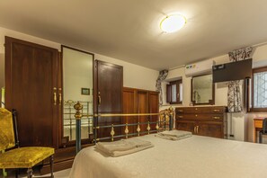 Quarto com cama, cadeira, guarda-roupa e espelho.