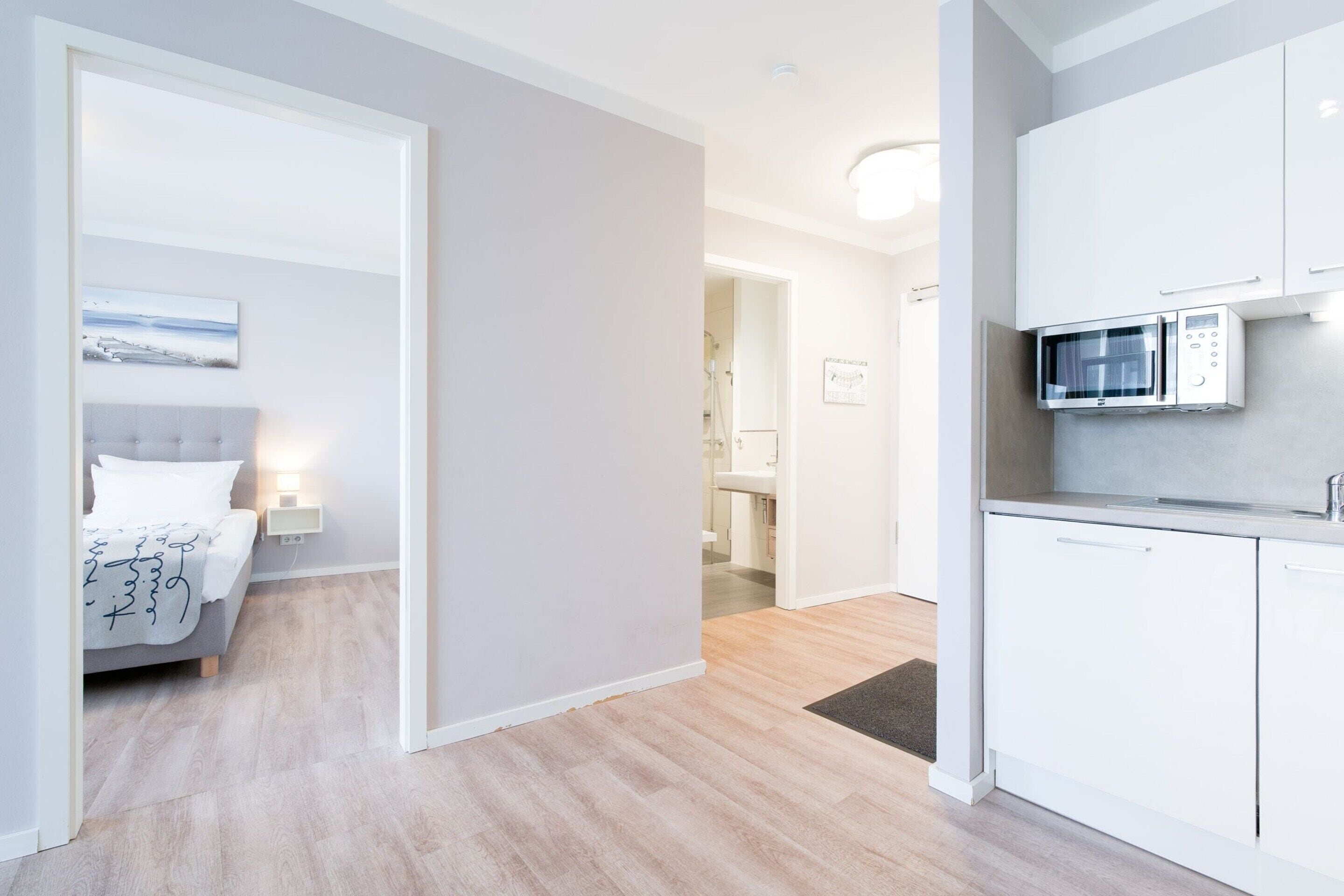 Um apartamento moderno com um quarto, cozinha e banheiro.