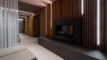 Interior moderno com lareira embutida, painéis de madeira e área de estar.