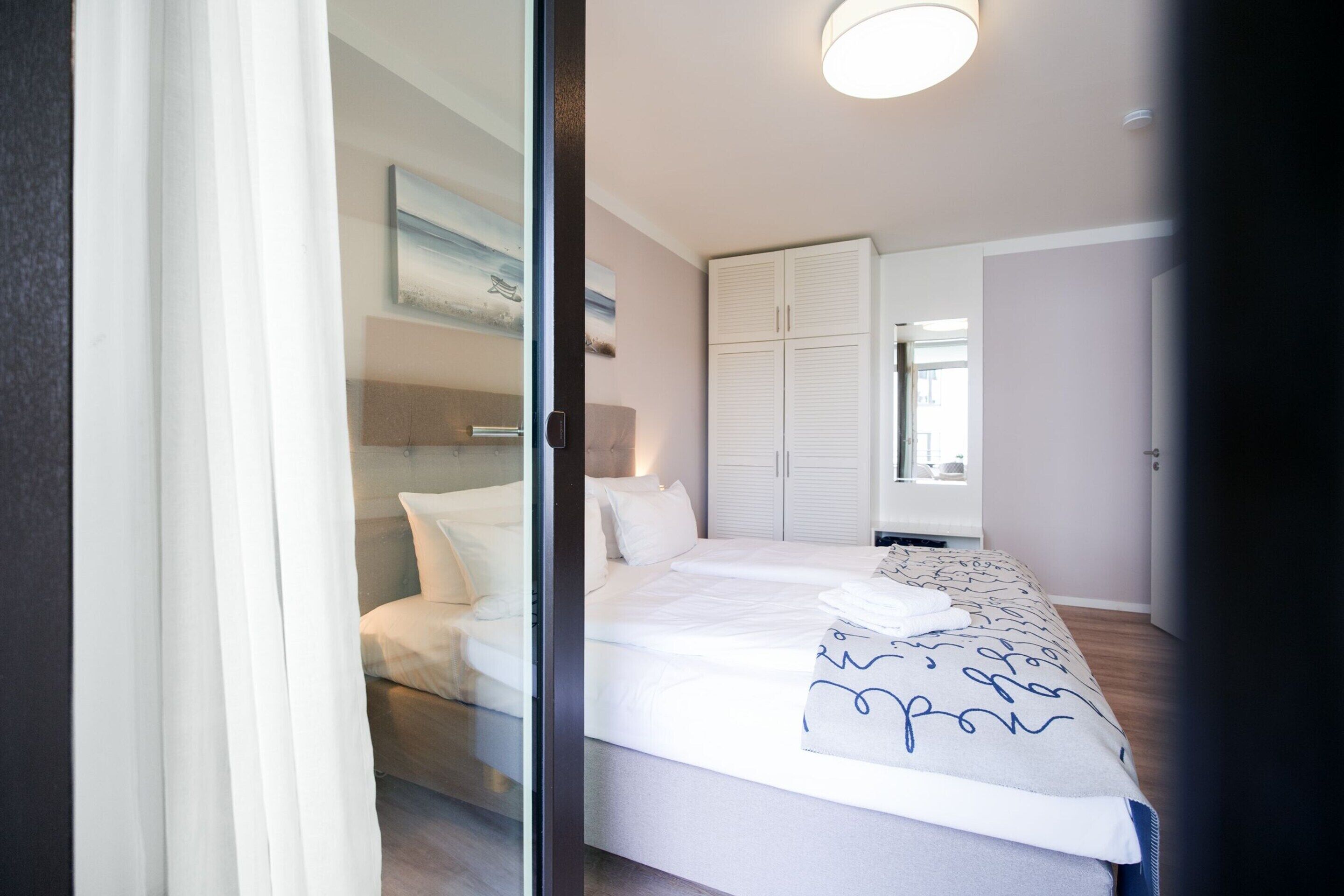 Quarto com cama, guarda-roupa e janela.