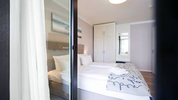 Quarto com cama, guarda-roupa e janela.