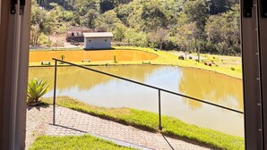 Visão através de uma porta, revelando um edifício com teto de madeira e luminária pendente.