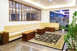 A modern living room with a sectional sofa, wooden side tables, and a patterned rug.
