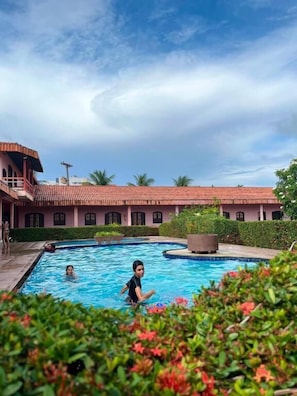 Piscina com um edifício ao fundo.