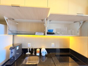 Cozinha moderna equipada com lava-louças embutida, pia e bancada com cafeteira.
