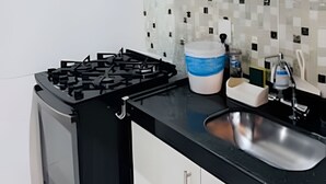 Uma cozinha moderna com fogão a gás, micro-ondas e pia.