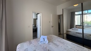 Quarto de hotel com cama, banheiro e vista para o exterior.