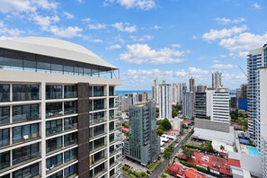 Um edifício alto com várias varandas e um design arquitetônico moderno.