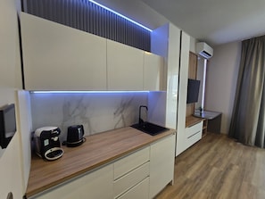 Uma cozinha moderna equipada com micro-ondas, cafeteira e pia.