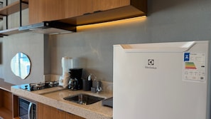 Cozinha com geladeira branca Electrolux, cafeteira e pia.