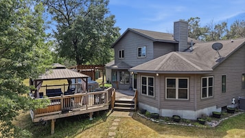 A two-story house with a deck, a covered patio, and a satellite dish.