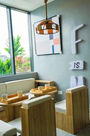 Quarto moderno com sofá, mesa de cabeceira de madeira e luminária pendente.