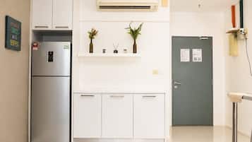 Uma cozinha moderna com geladeira embutida, ar-condicionado fixado na parede e porta com painel de serviço.