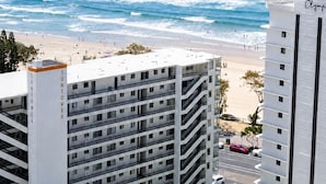 Um hotel com vários andares, com vista para a praia e o oceano.
