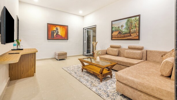 Uma sala de estar moderna com sofá, mesa de centro e obras de arte nas paredes.
