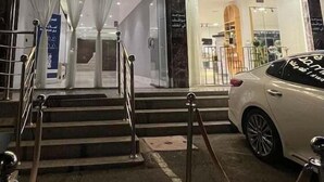 Entrada de hotel com um letreiro indicando 'Apartamentos' e 'Parque com serviço'.