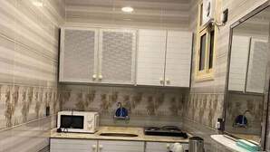 Uma cozinha compacta com micro-ondas, pia e armários.