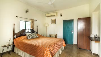 Um quarto com cama, janela, porta, ventoinha no teto e ar-condicionado fixado na parede.