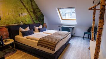 Um quarto com uma cama grande, uma escrivaninha, uma cadeira, uma janela e um mural na parede.