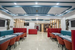 Um restaurante com cabines e mesas, piso ladrilhado e design de teto moderno.