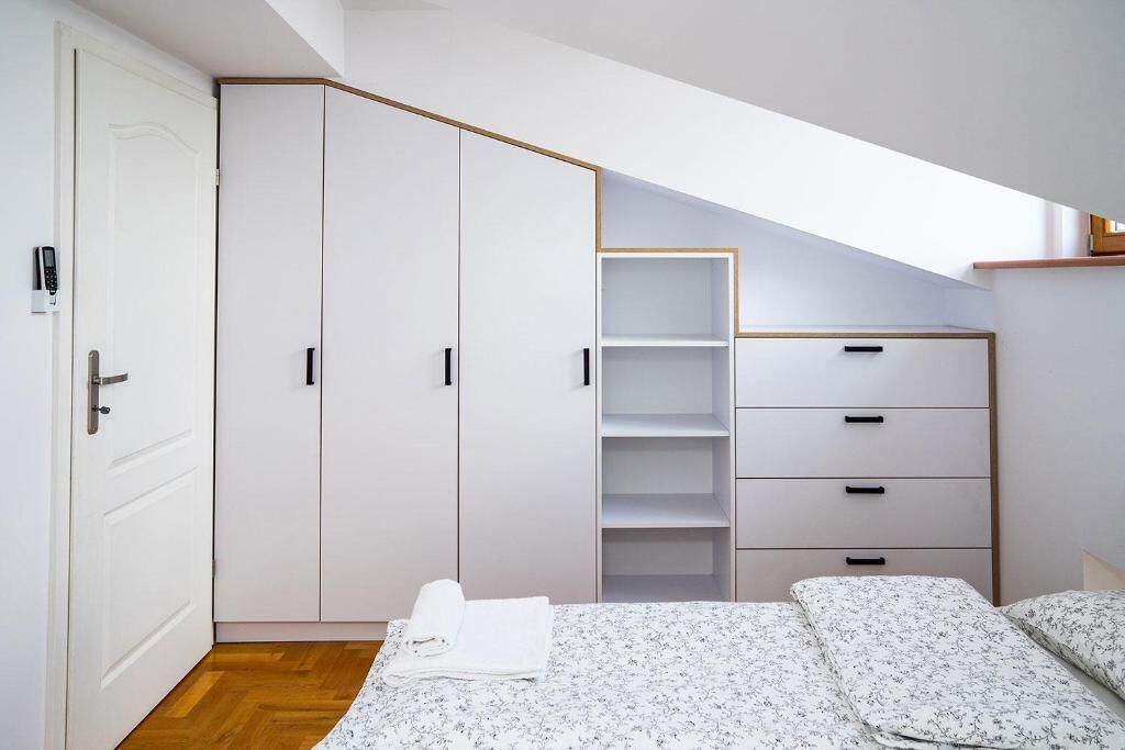 Quarto com cama, guarda-roupa e estante embutida.