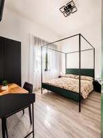 Um quarto moderno com uma cama de dossel, uma escrivaninha de madeira e uma cadeira.
