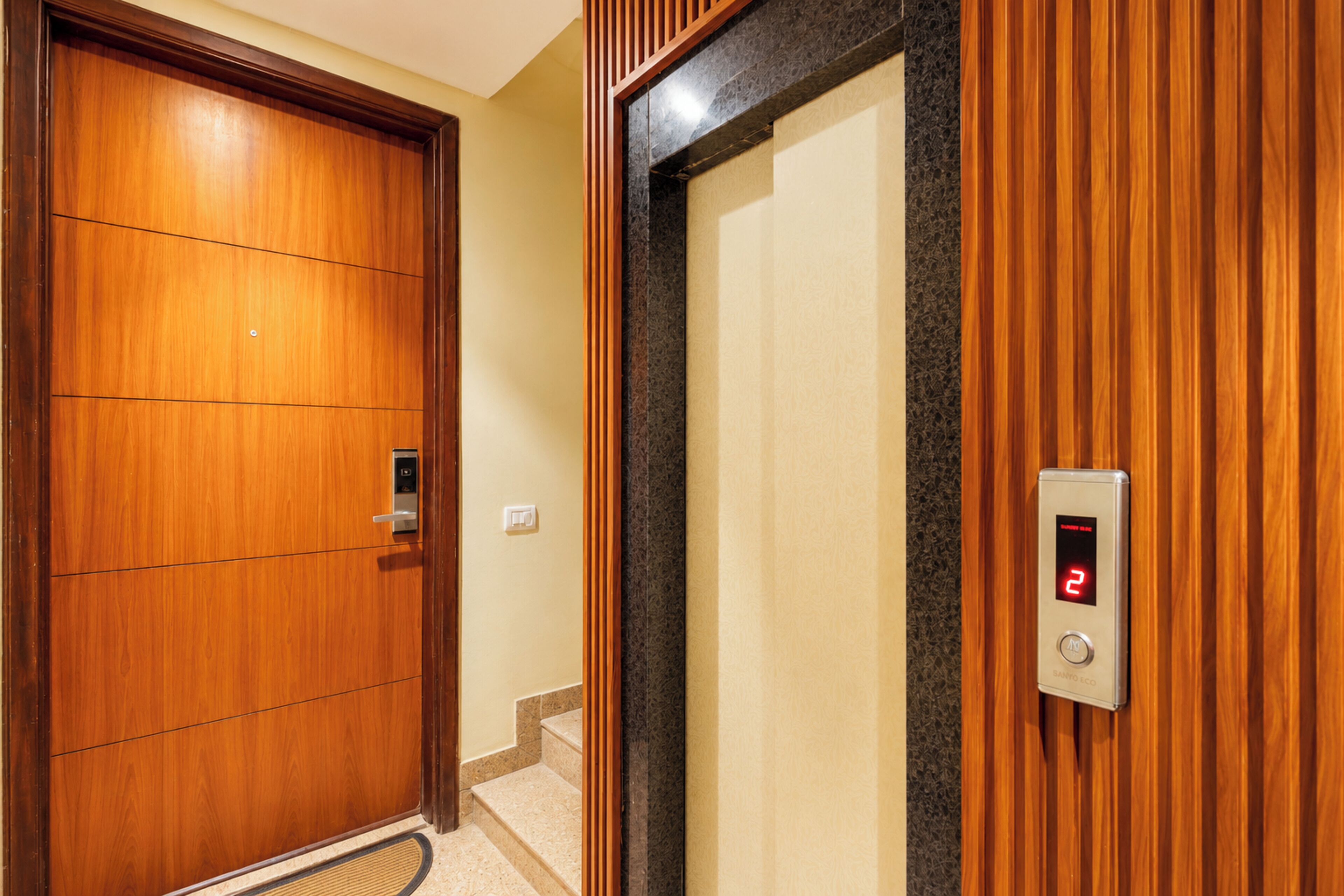 Uma porta de madeira com um painel de controle de elevador digital mostrando o número 2.