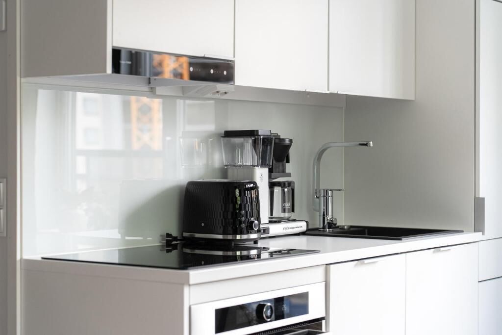 Uma cozinha moderna com cafeteira, torradeira e pia.