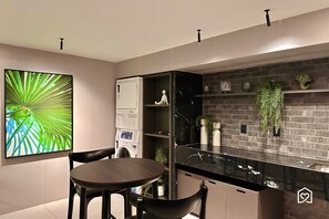 Uma cozinha moderna com bancada de mármore preto, forno embutido e backsplash de tijolos.