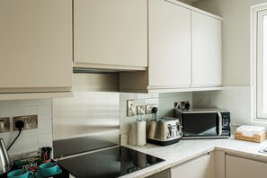 Uma cozinha moderna com eletrodomésticos de aço inoxidável, micro-ondas e torradeira.