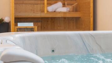 Uma banheira de hidromassagem com uma cabana de madeira ao fundo.
